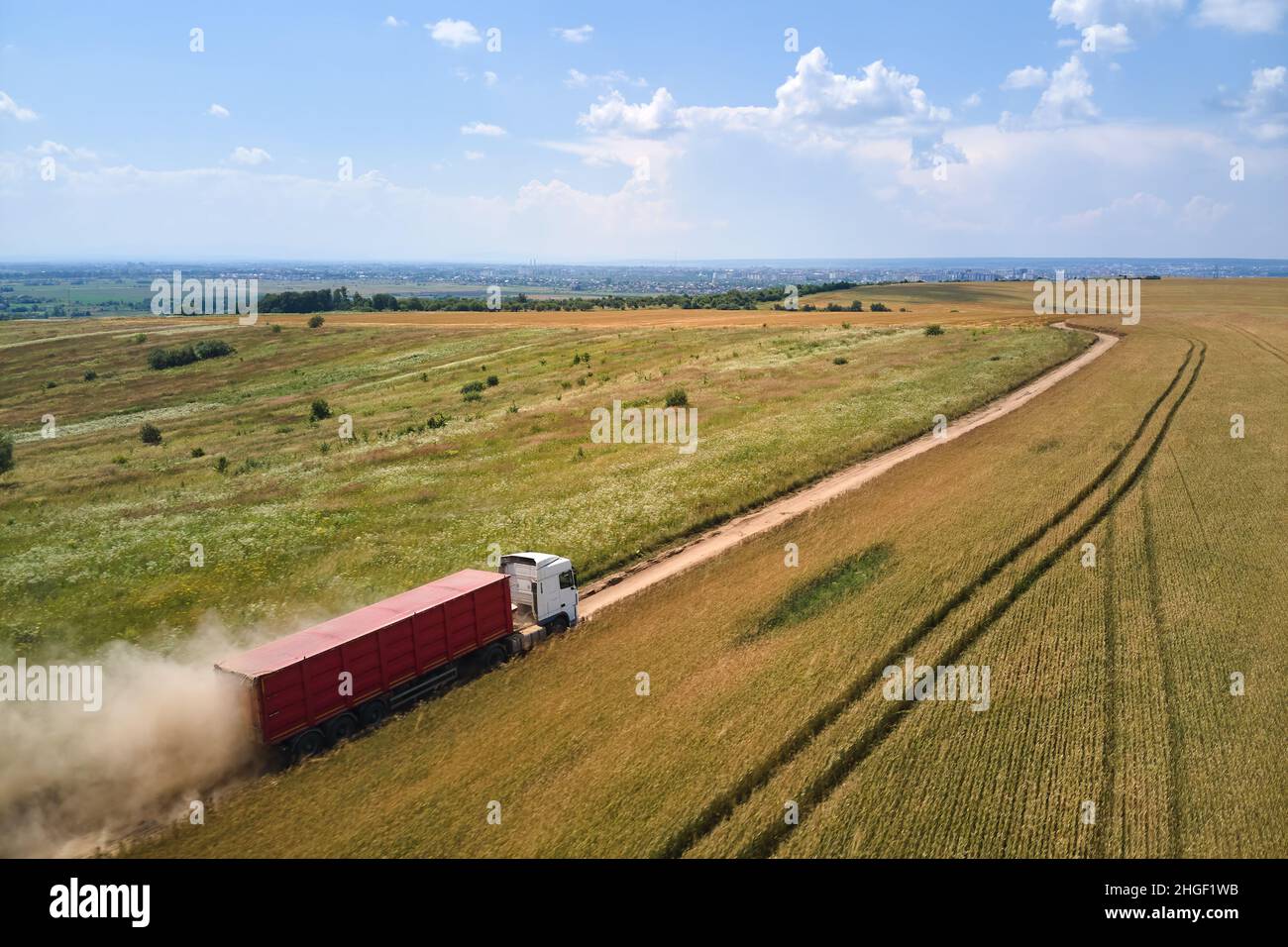 Aerial view of lorry cargo truck driving on dirt road between ...