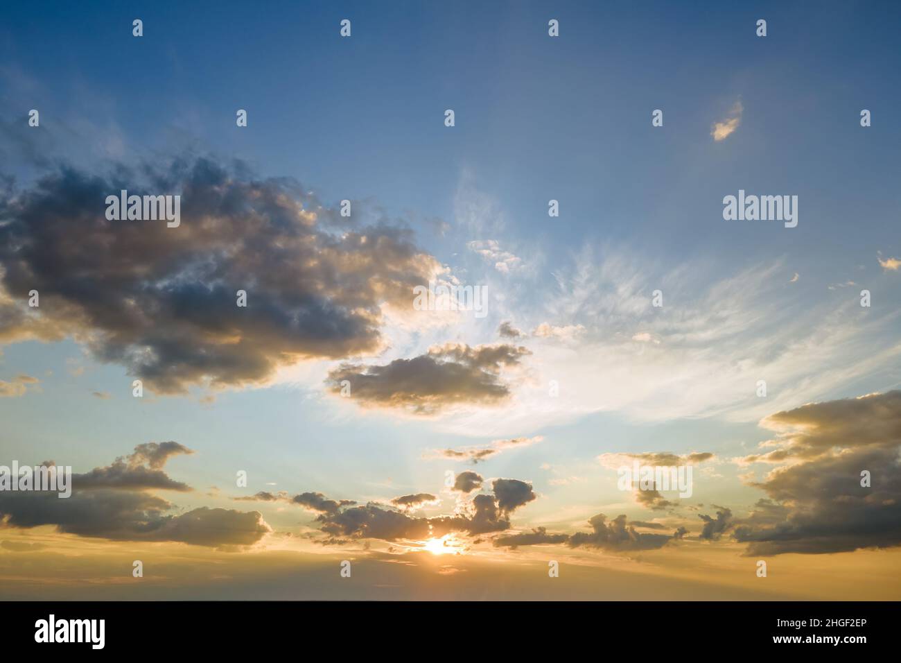 Bright colorful sunset sky with setting sun and vivid soft clouds ...