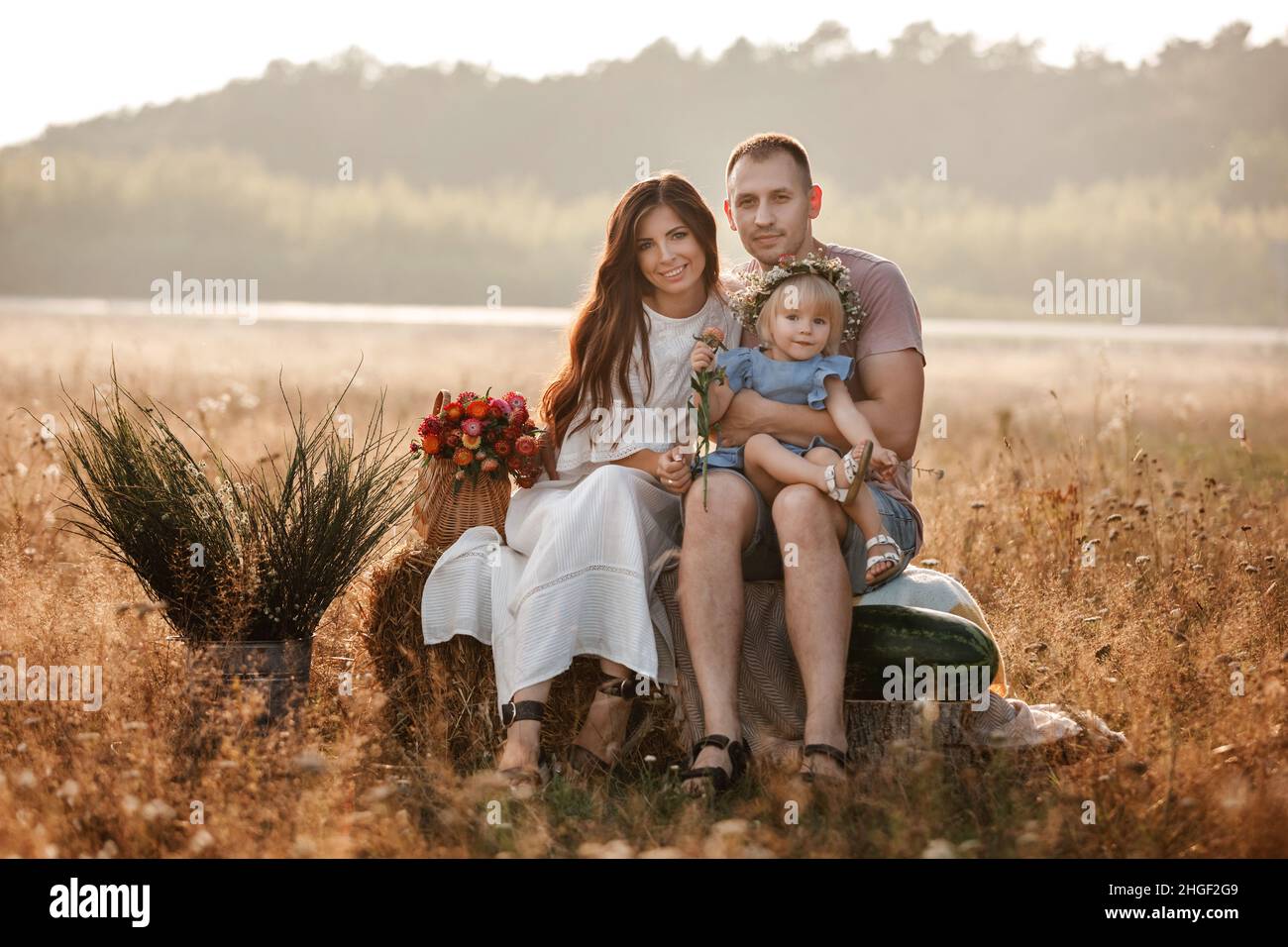 Happy family together: beautiful young parents in white clothes hugging ...
