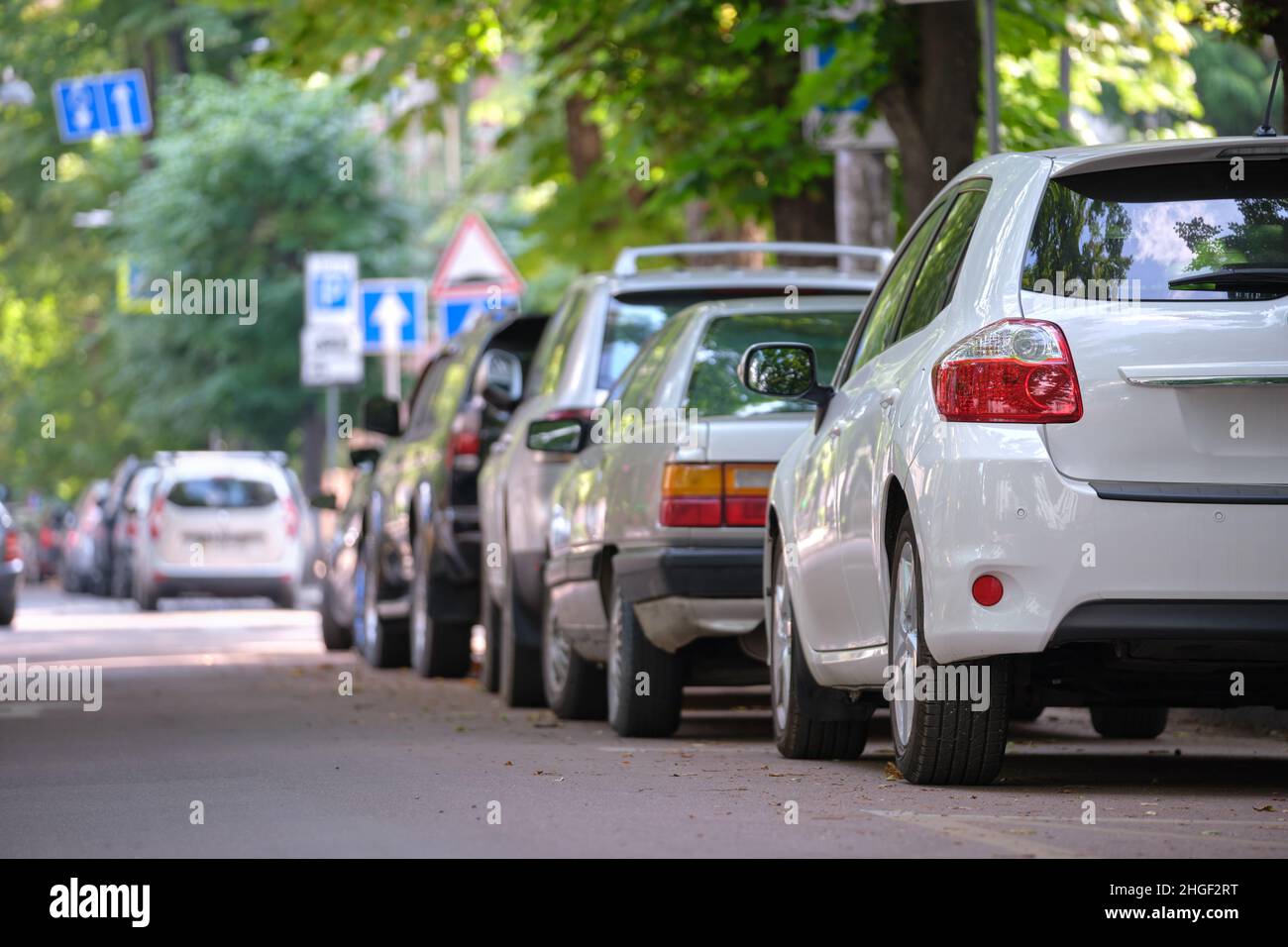 City traffic with cars parked in line on street side Stock Photo - Alamy