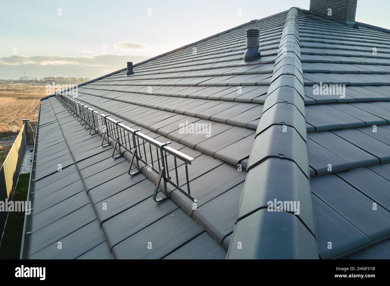 Closeup of house roof top covered with ceramic shingles. Tiled covering ...