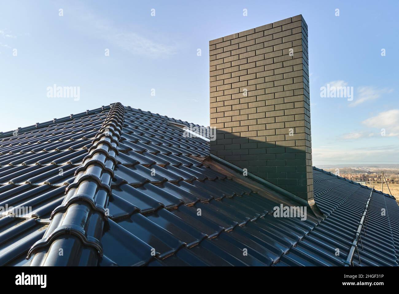 Closeup of brick chimney on house roof top covered with ceramic ...