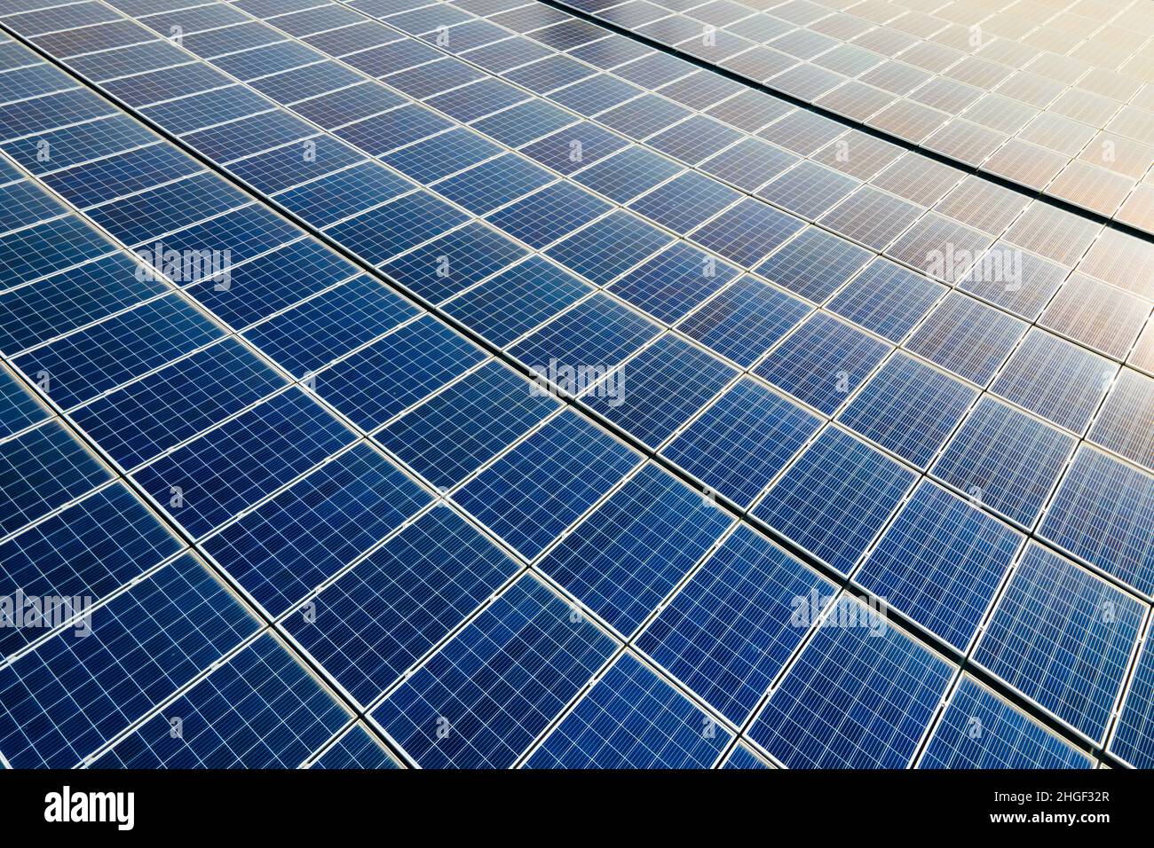 Closeup of surface of blue photovoltaic solar panels mounted on building roof for producing ...