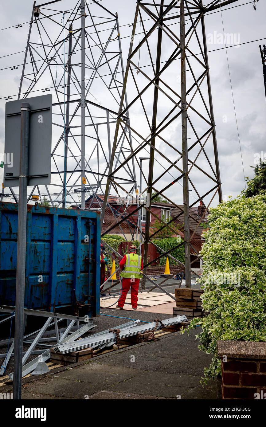 Workmen in PPE use oxy acetylene torches to cut out damaged parts of a ...