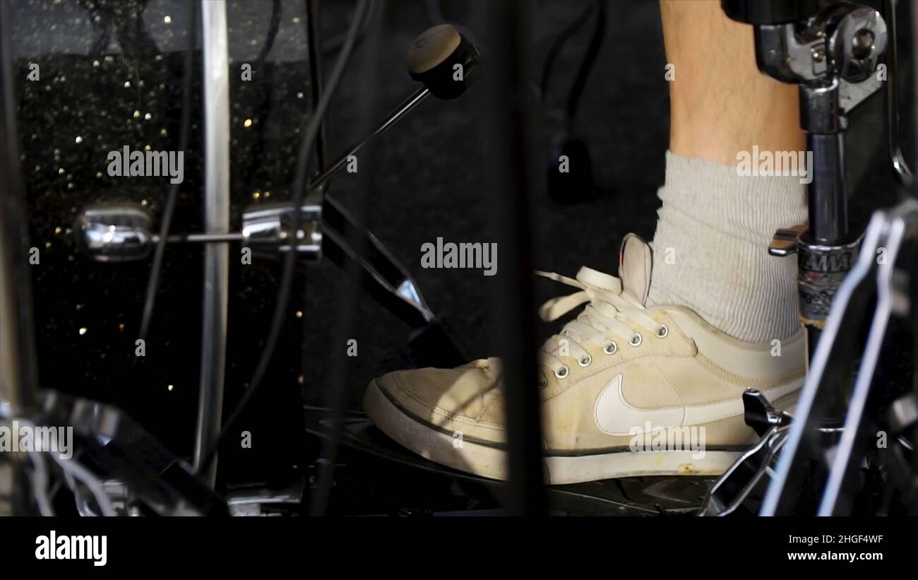 Drummer's foot in sneakers moving drum bass pedal. Clip. Part of legs ...
