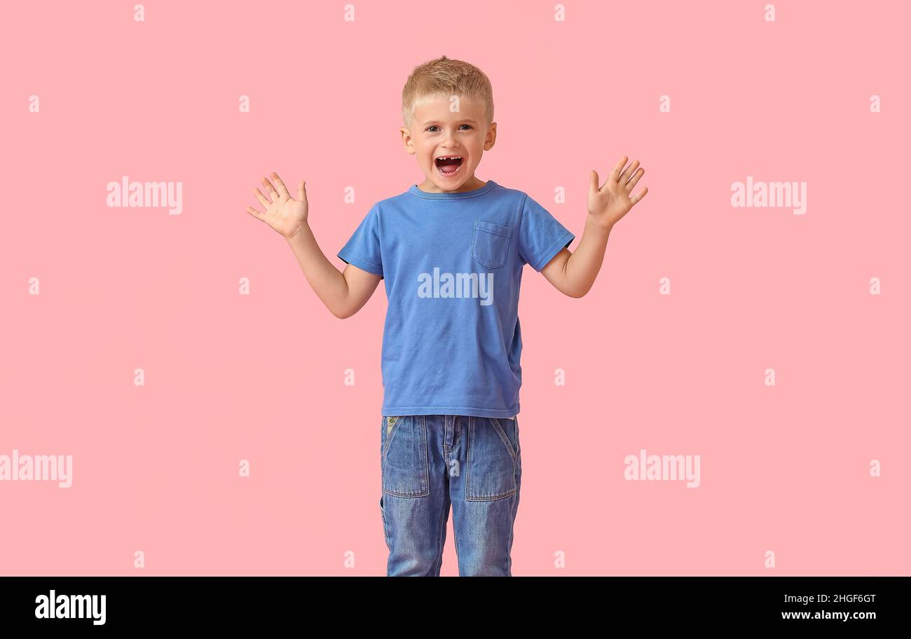 Emotional little boy in blue t-shirt on pink background Stock Photo - Alamy