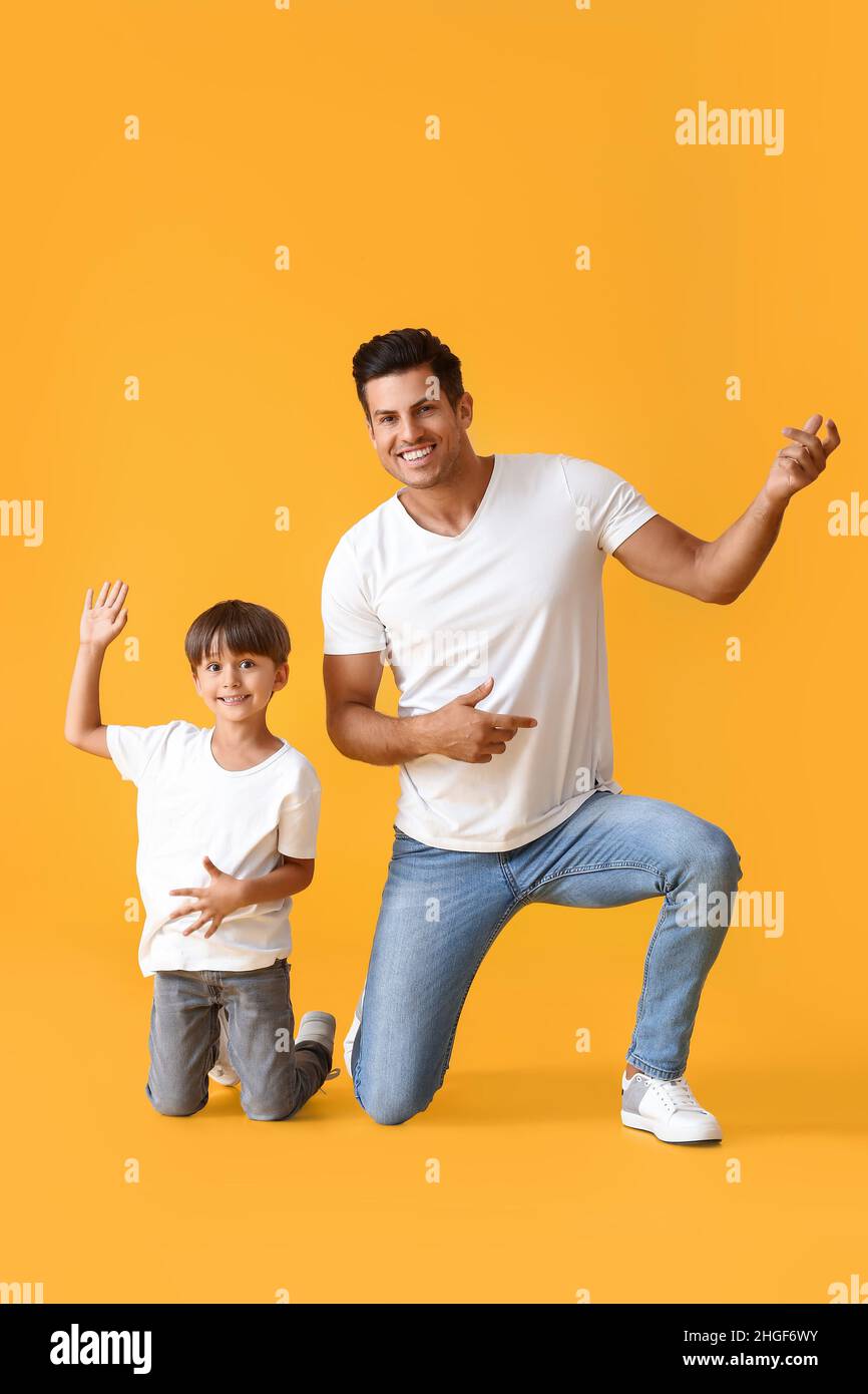 Happy dancing man and his son on color background Stock Photo - Alamy