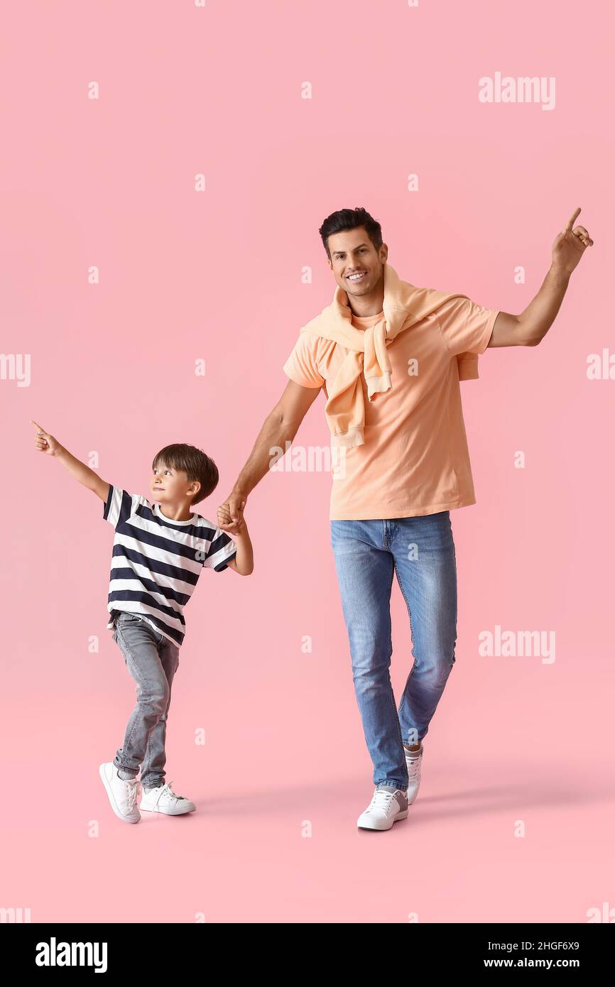 Happy dancing man and his son on color background Stock Photo - Alamy