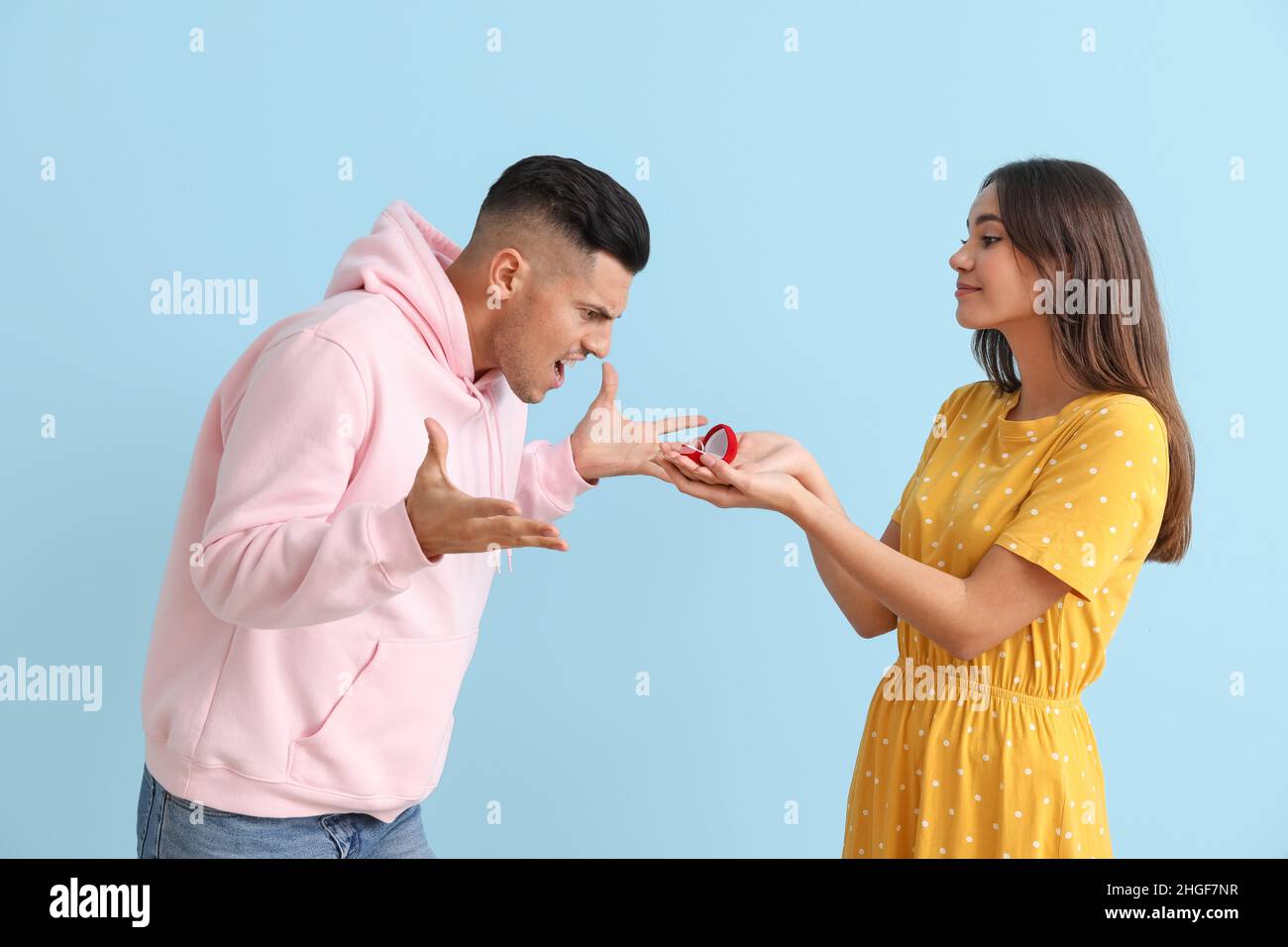 Angry young man rejecting marriage proposal on color background Stock ...