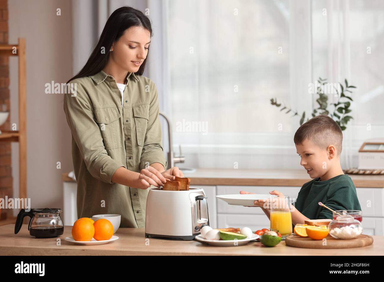 Little boy with his mother making tasty toasts in kitchen Stock Photo ...