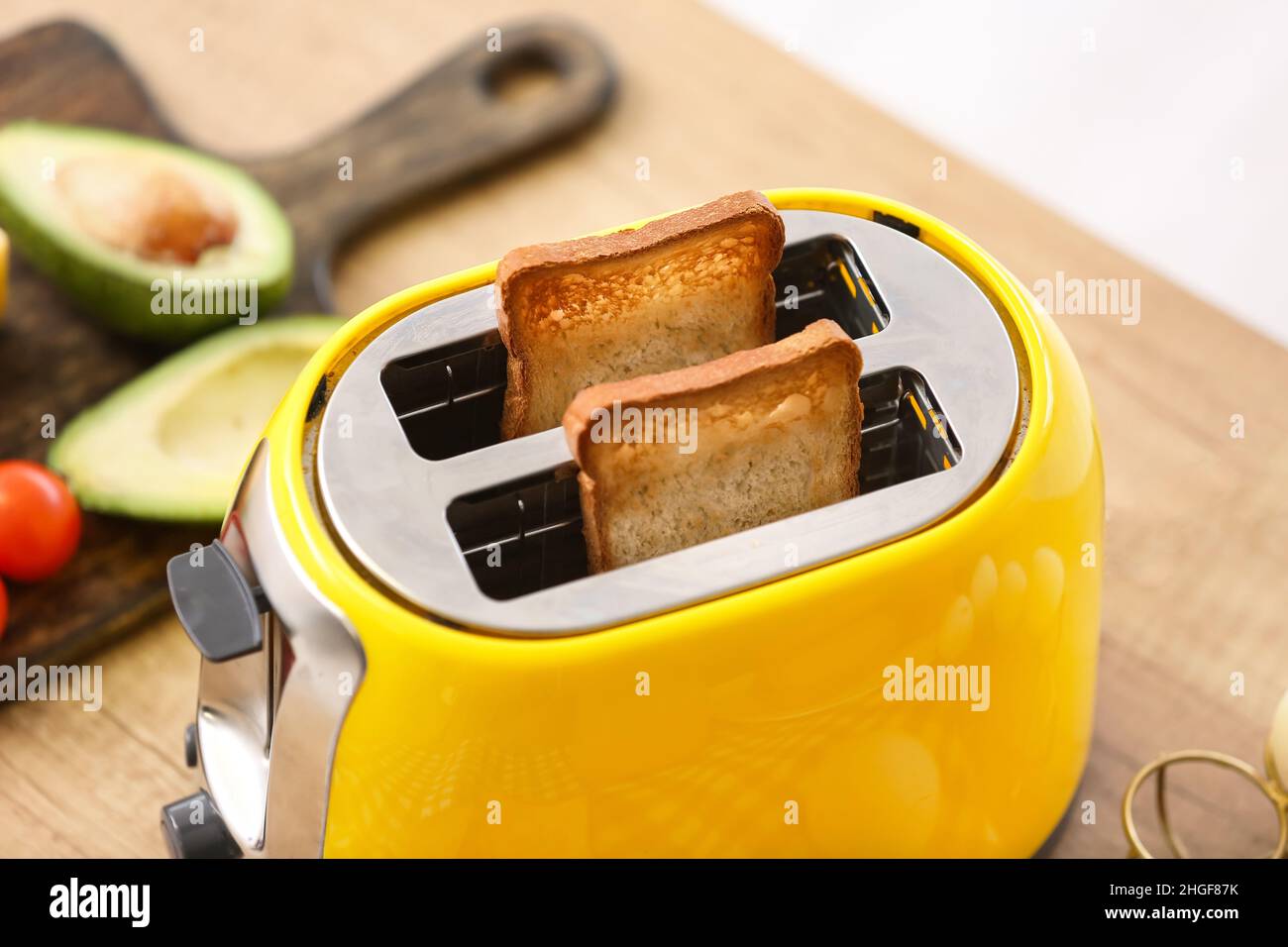 Yellow toaster with bread slices in kitchen, closeup Stock Photo - Alamy