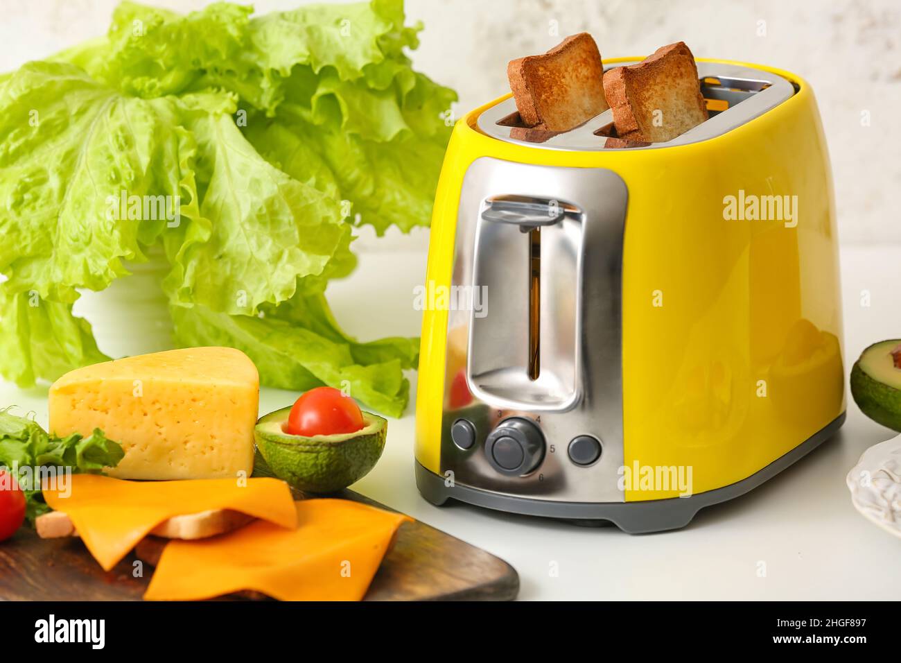 Yellow toaster with healthy food on table in kitchen Stock Photo - Alamy