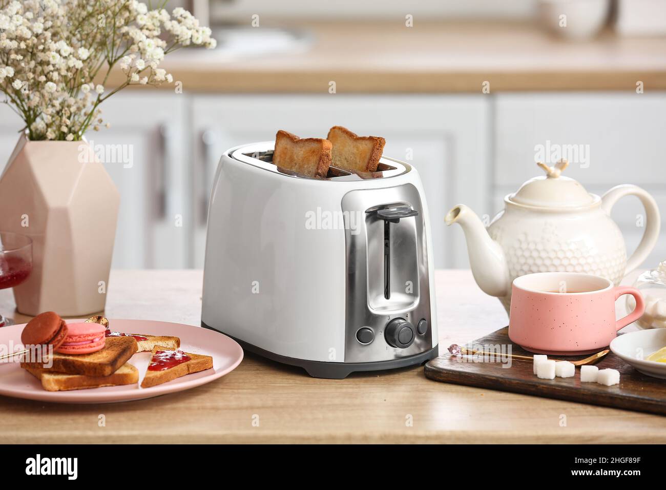 White toaster with tasty food, drink and vase on counter in kitchen Stock Photo - Alamy
