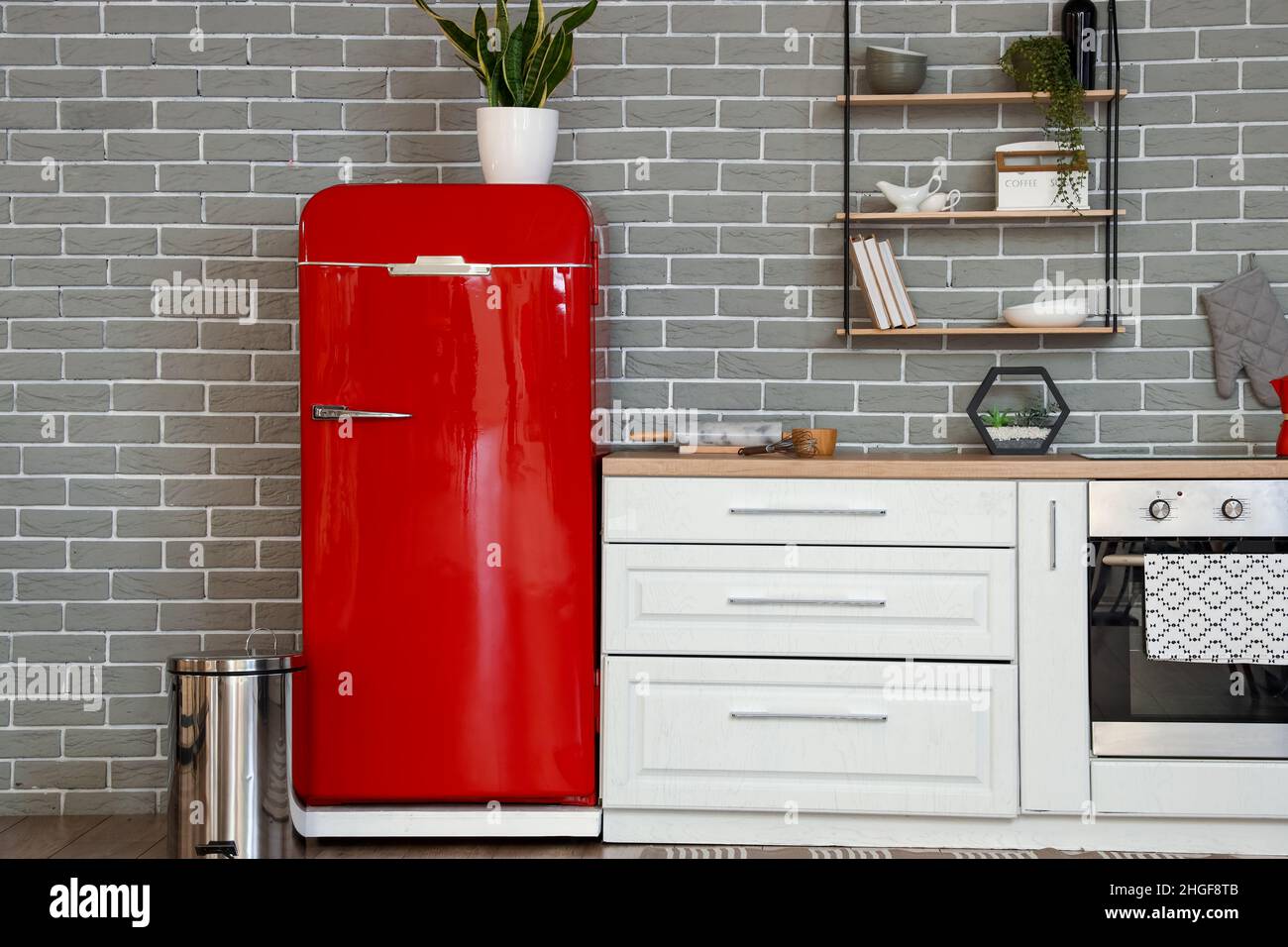 Interior of stylish kitchen with red fridge, white counters and brick ...