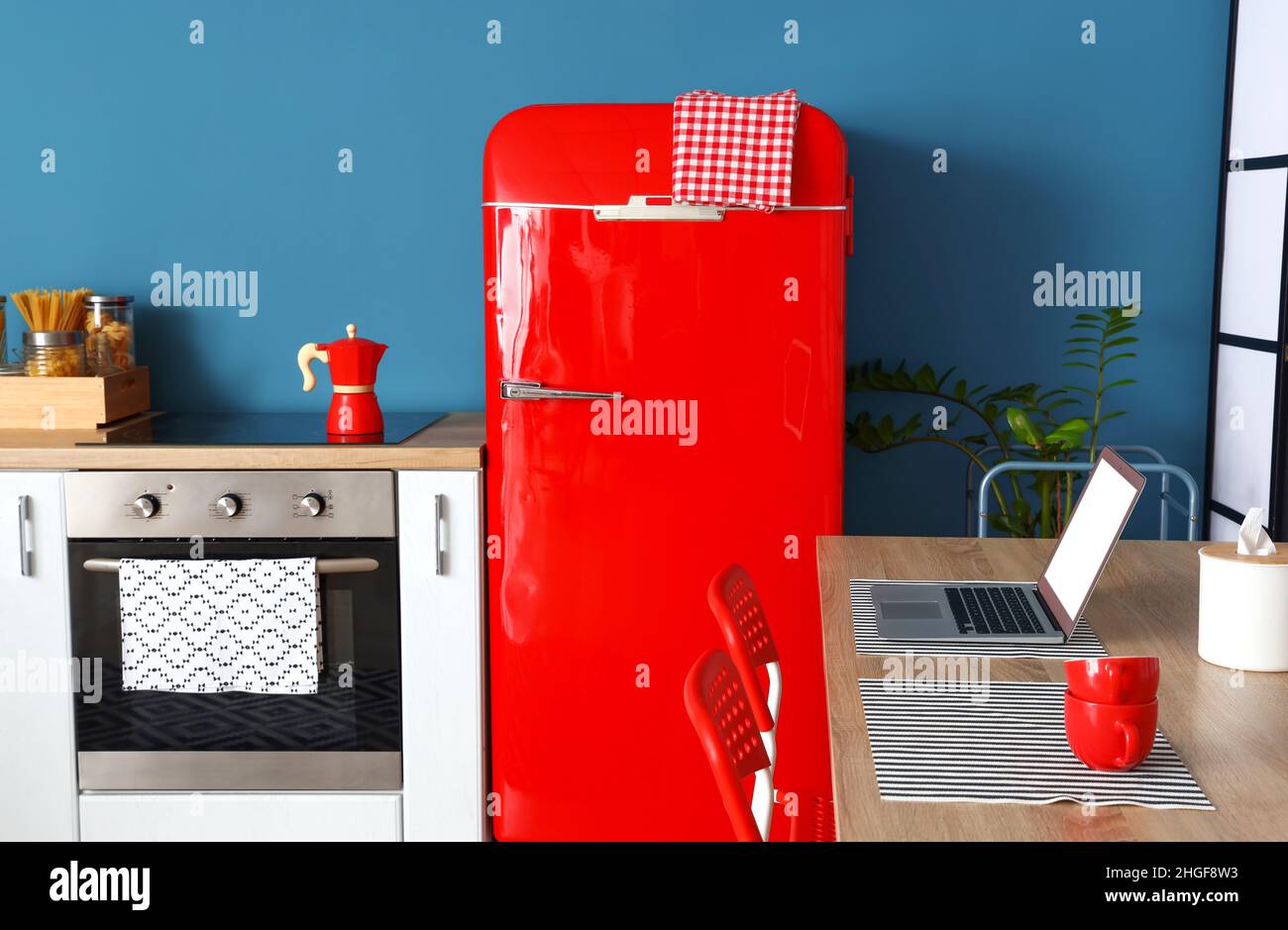 Interior of stylish kitchen with red fridge, oven and dining table ...