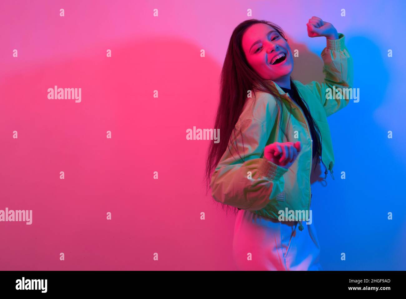 The brunette dances in neon, the dancer in red-blue. Hip hop girl ...