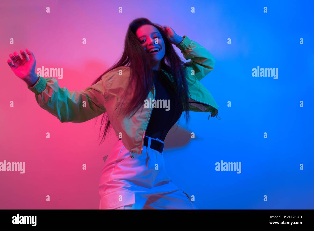 The brunette dances in neon, the dancer in red-blue. Hip hop girl ...