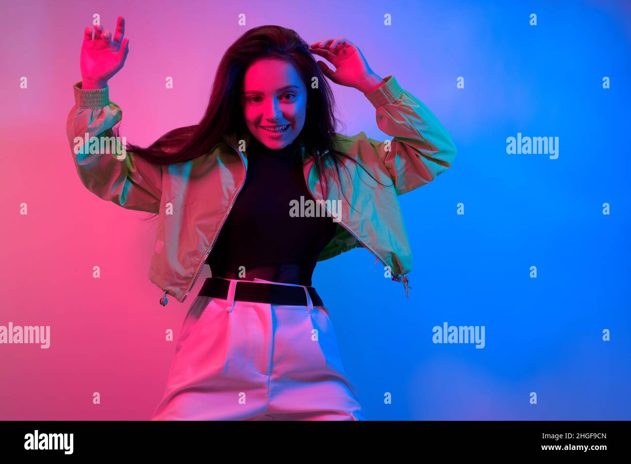 The brunette dances in neon, the dancer in red-blue. Hip hop girl ...