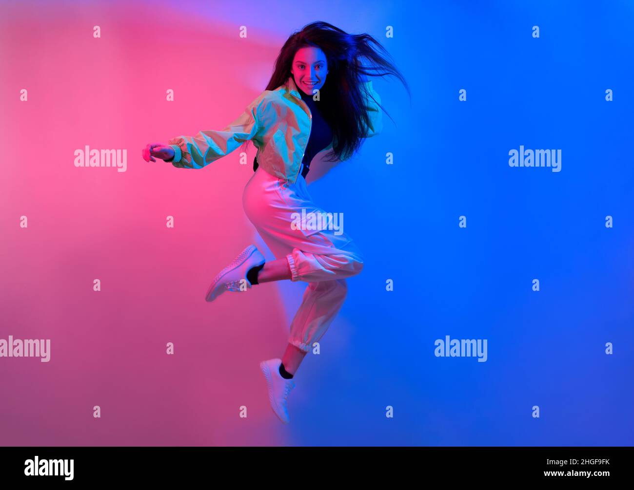 The brunette dances in neon, the dancer in red-blue. Hip hop girl ...