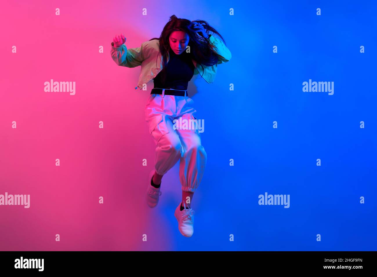 The brunette dances in neon, the dancer in red-blue. Hip hop girl ...