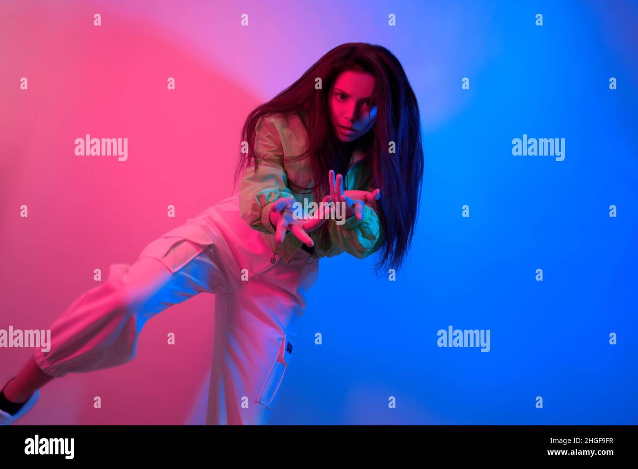 The brunette dances in neon, the dancer in red-blue. Hip hop girl ...