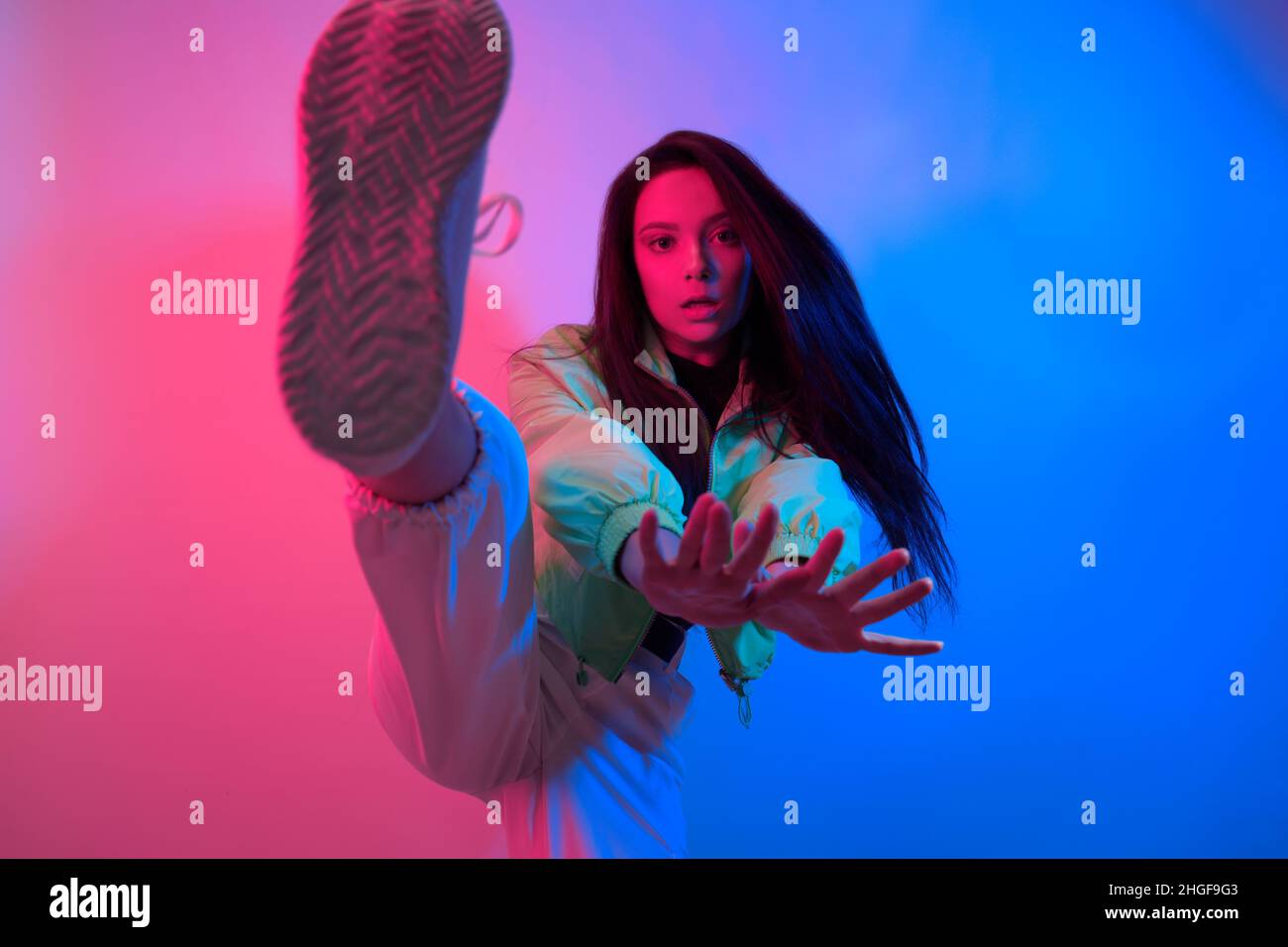 The brunette dances in neon, the dancer in red-blue. Hip hop girl ...