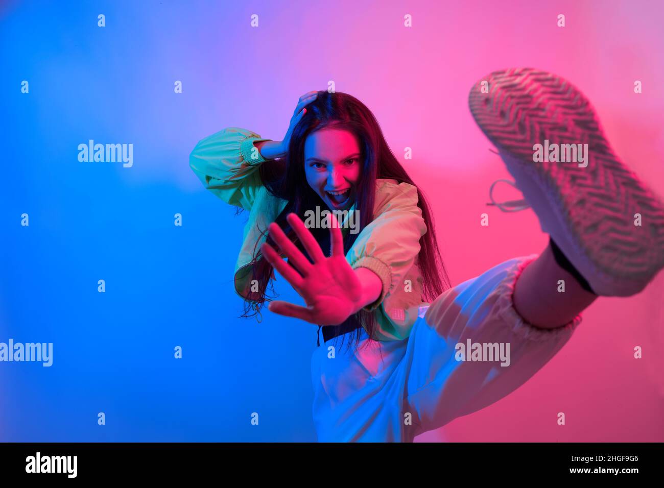 The brunette dances in neon, the dancer in red-blue. Hip hop girl ...