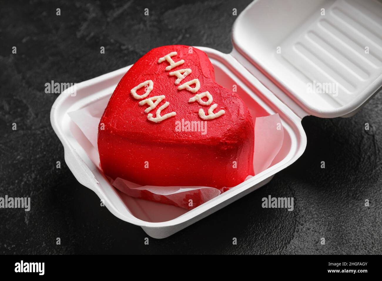 Plastic lunch box with tasty bento cake on dark background, closeup ...