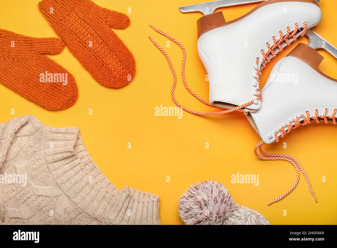 Frame made of ice skates and clothes on orange background Stock Photo ...