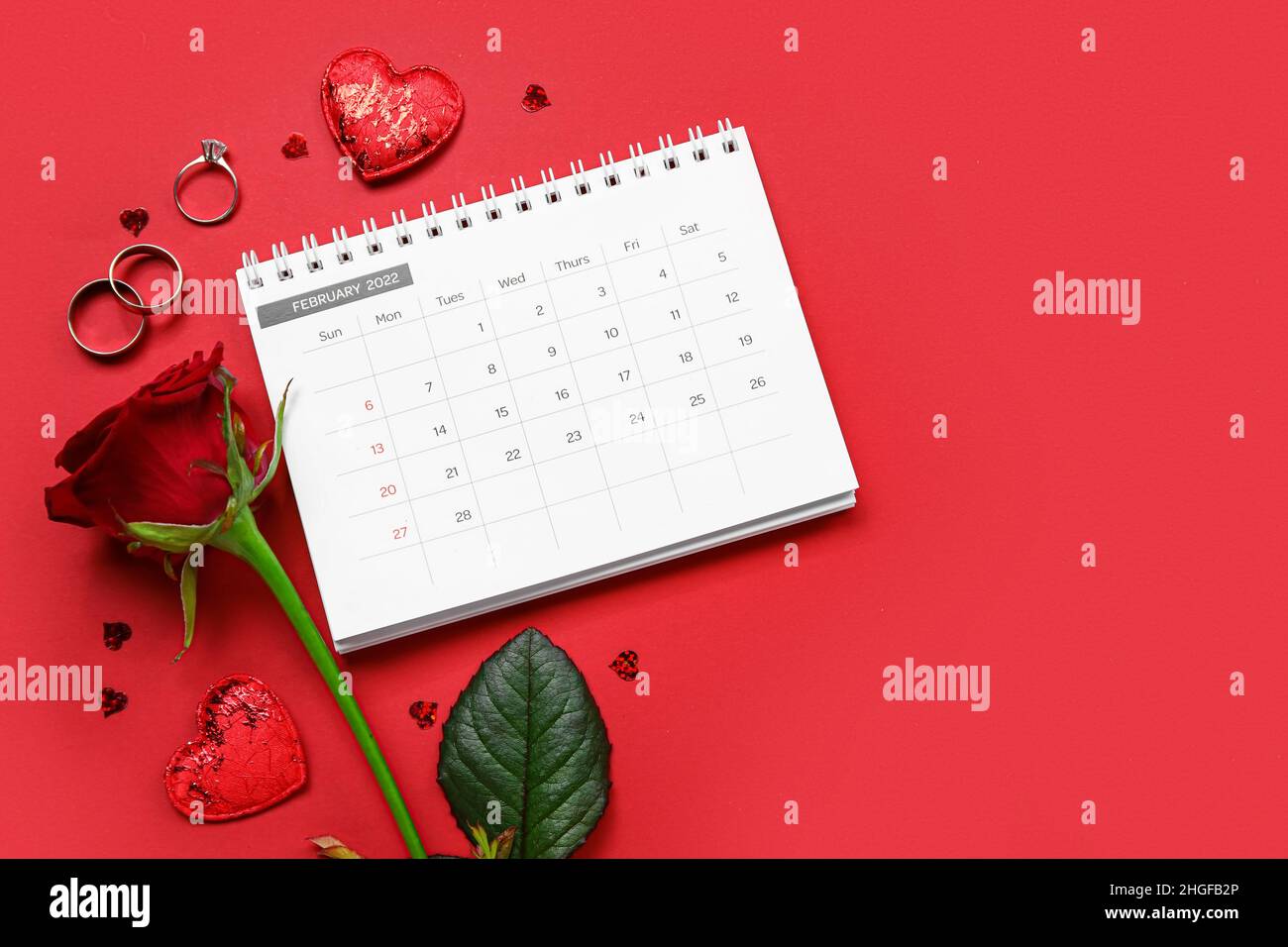 Calendar with rings, rose and hearts on red background. Valentine's Day ...