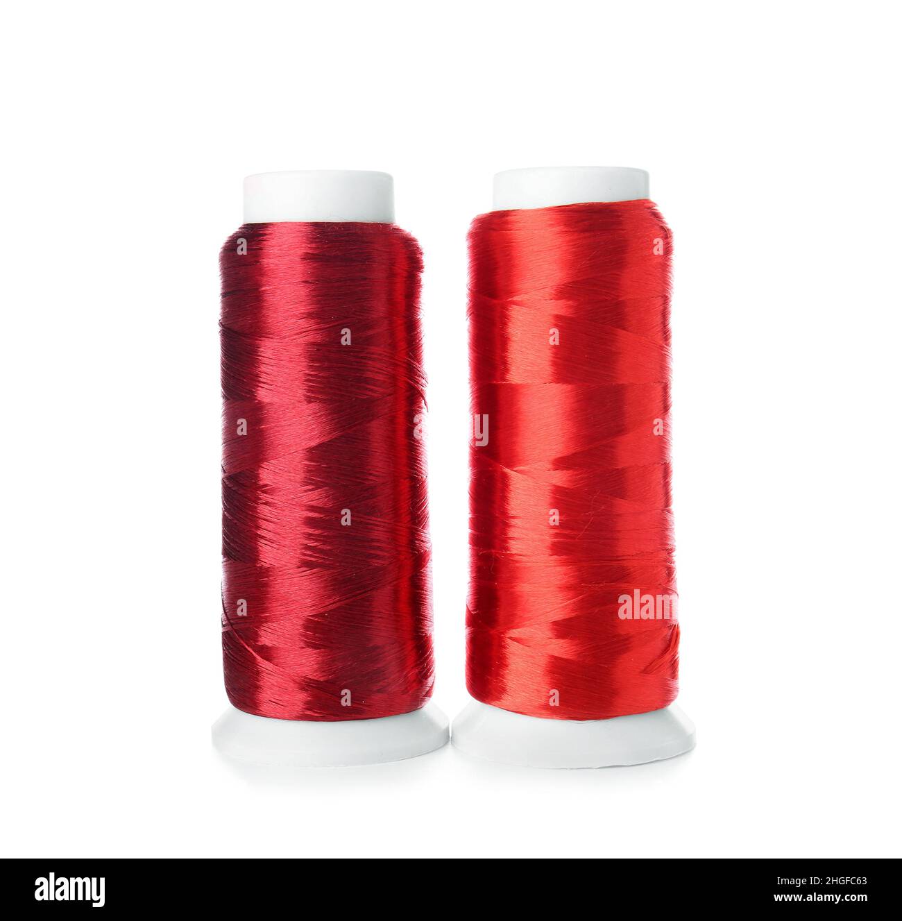 Red sewing thread spools on white background Stock Photo - Alamy