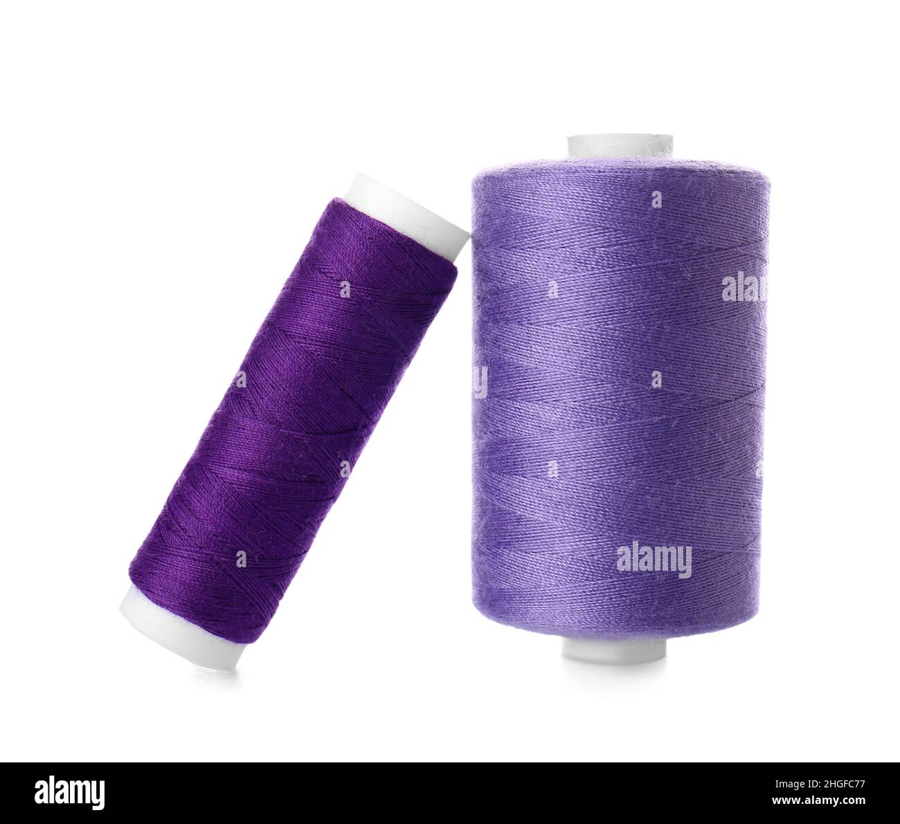 Purple sewing thread spools on white background Stock Photo - Alamy