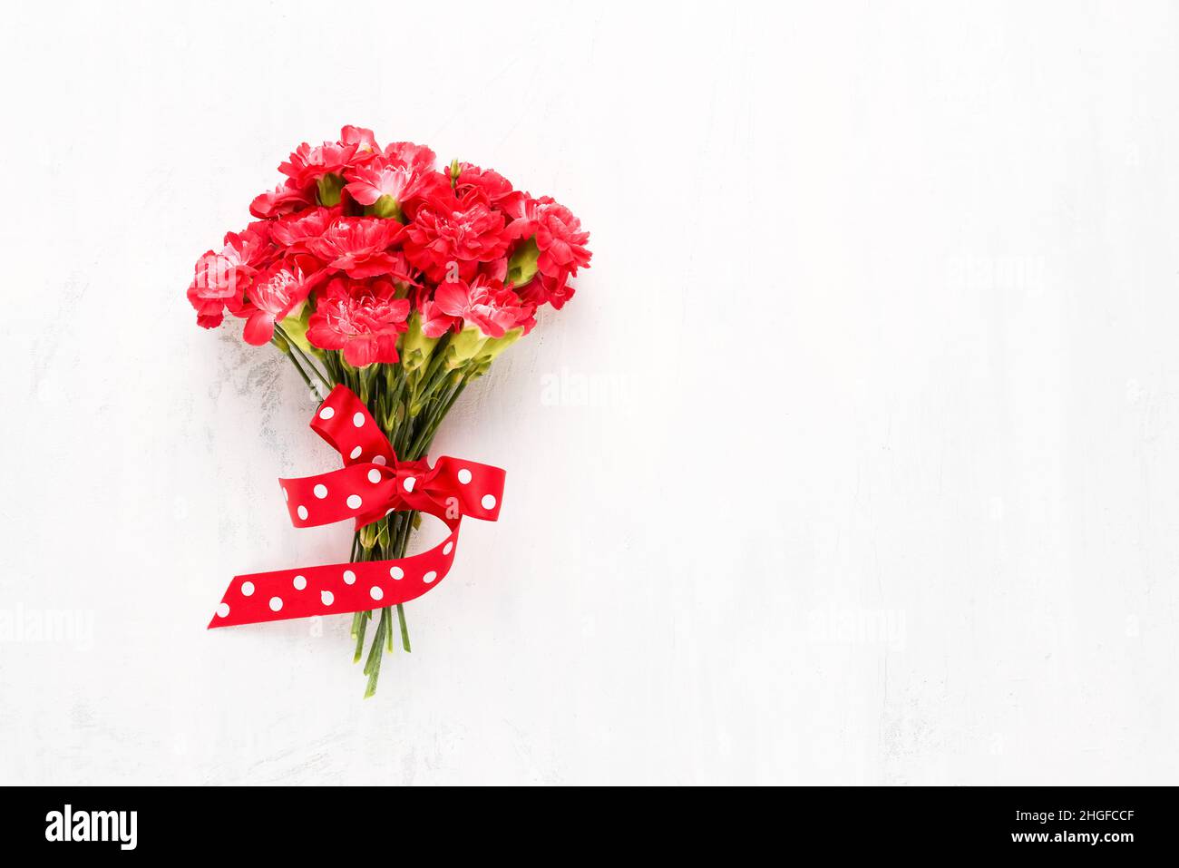 Red carnations flowers bouquet decorated with red ribbon on a white ...