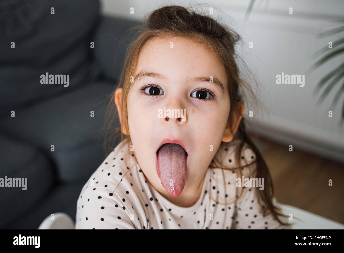 Portrait view of the little happy funny girl wearing pajamas sticking ...