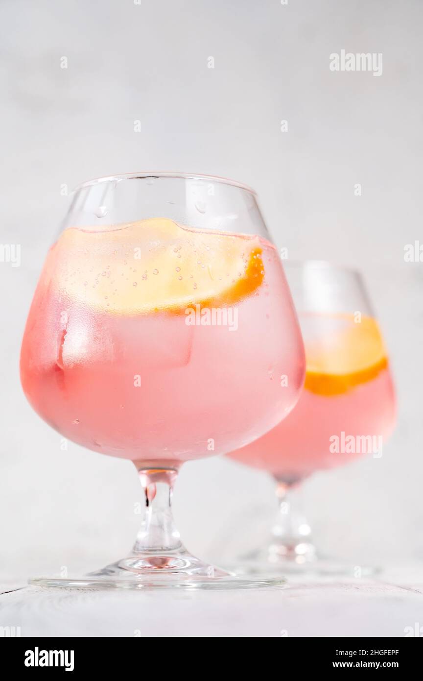 Pink vodka lemonade cocktail garnished with lemon wedge Stock Photo - Alamy