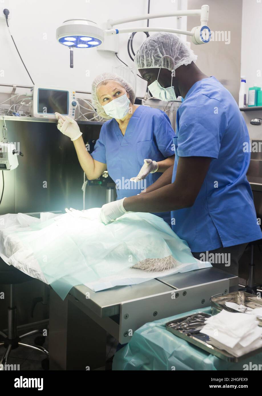 Nurse warns surgeon by pointing hand on computer screen Stock Photo - Alamy