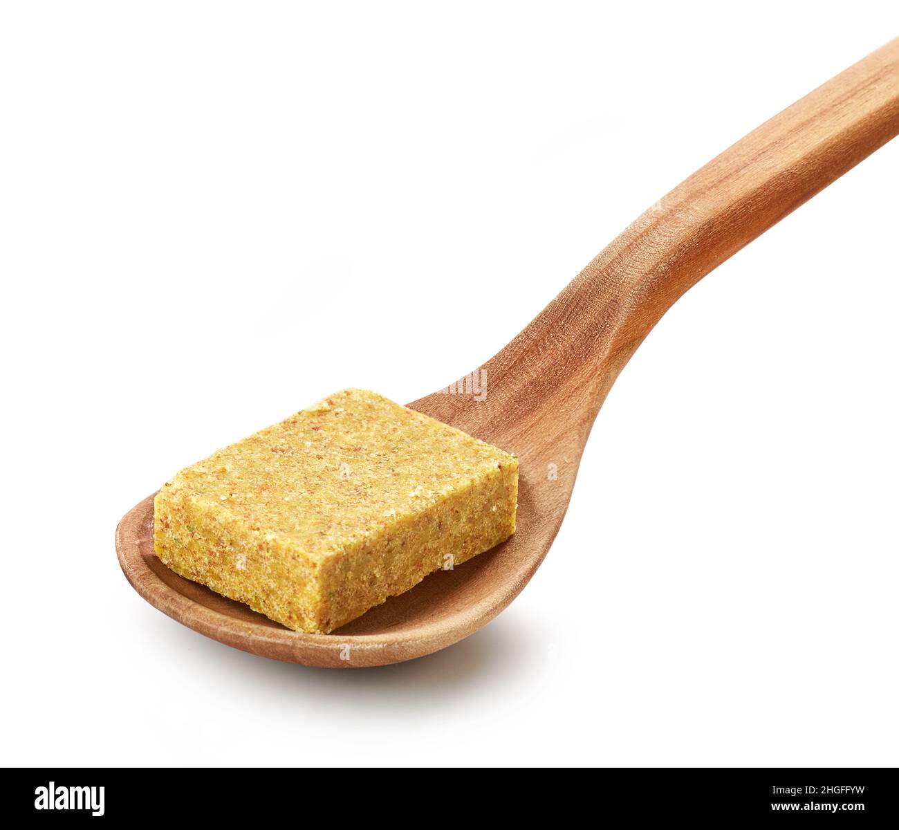 instant chicken broth cube in wooden spoon isolated on white background ...