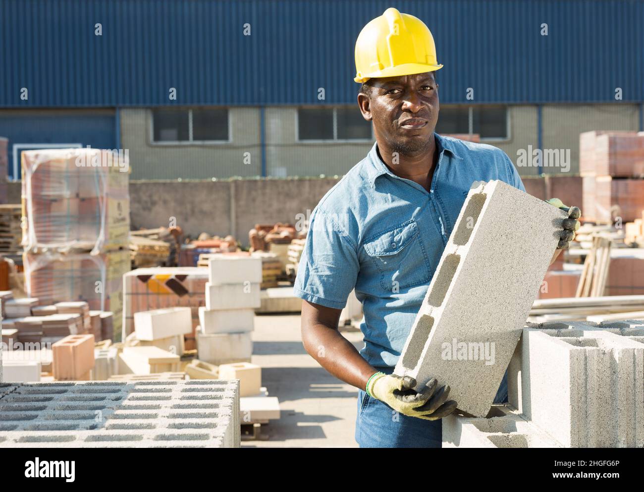 Worker stacking bricks in warehouse of building materials clpseup Stock ...