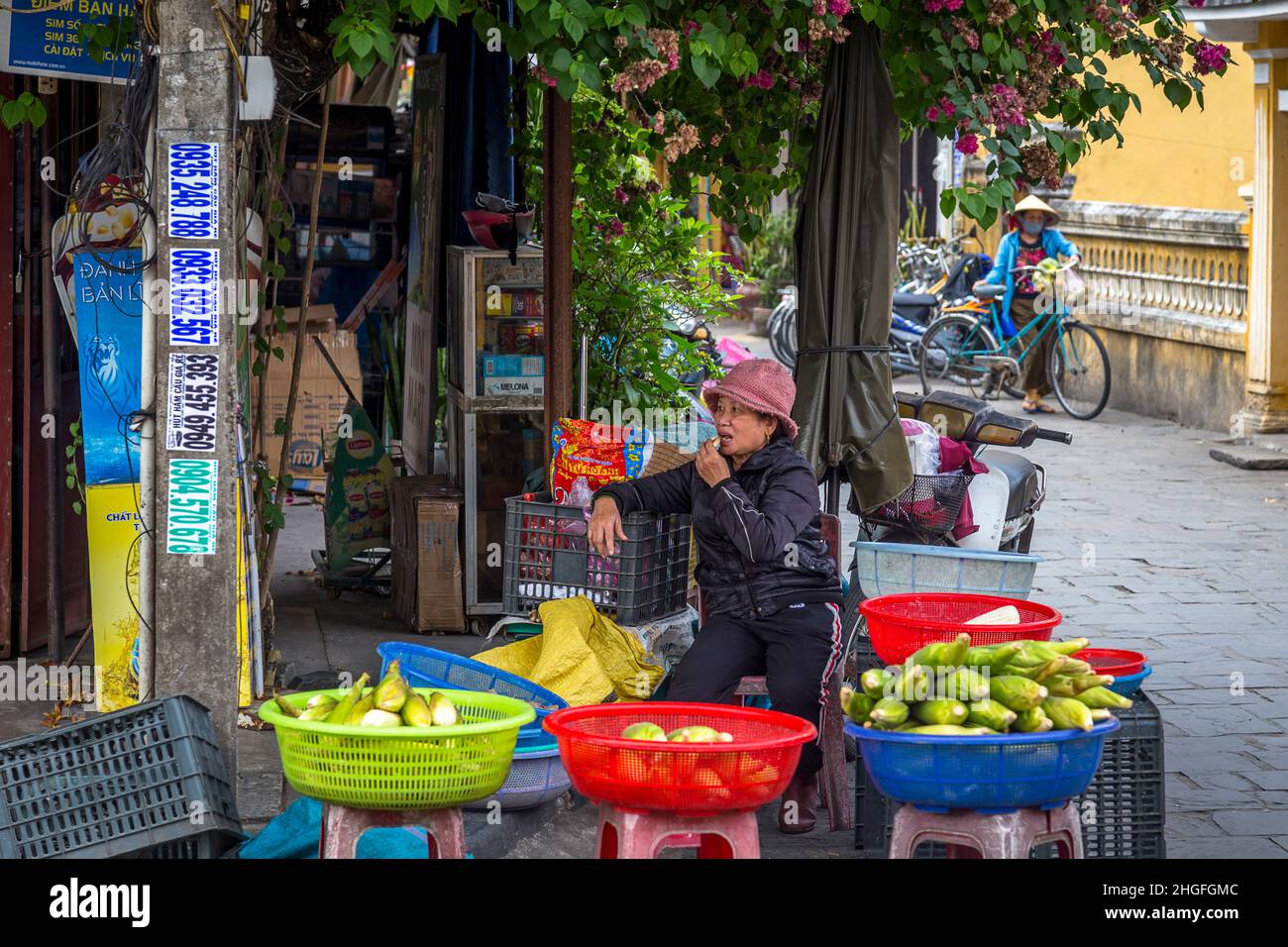 A Vietnamese woman sits on a corner selling her produce in Old Town ...