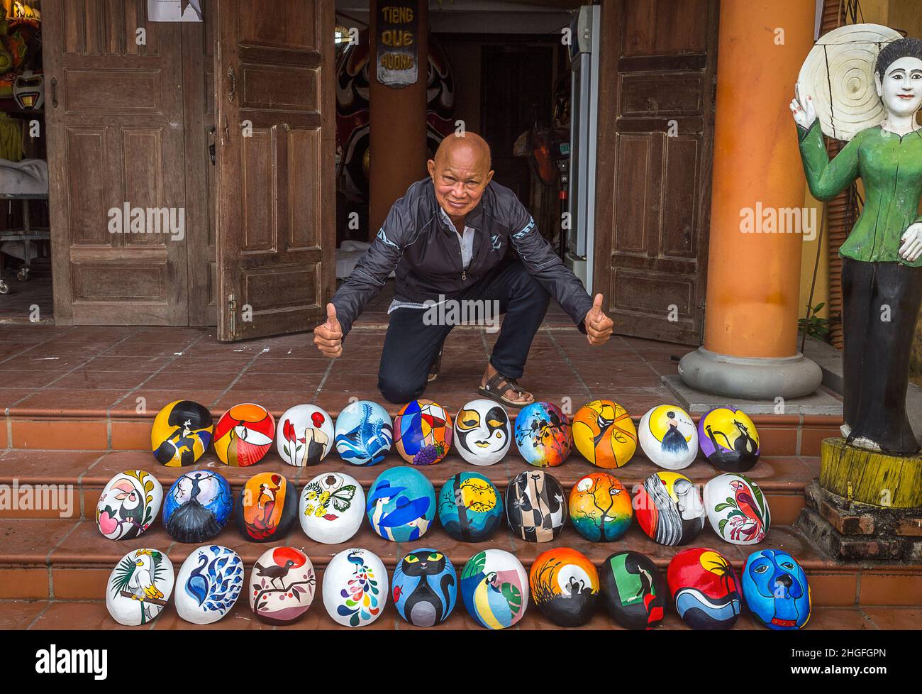 Shop owner teaches how to paint masks Stock Photo - Alamy