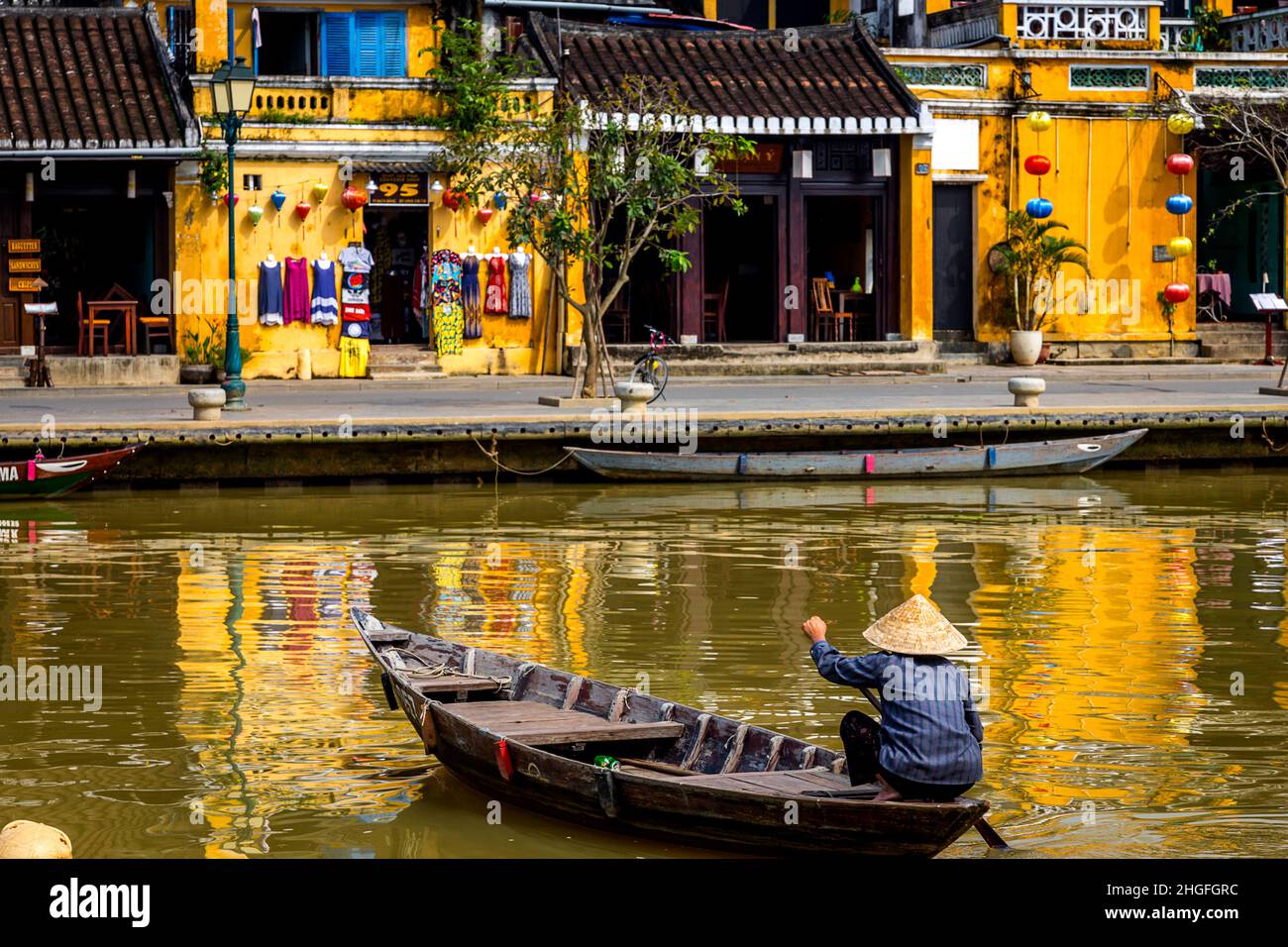A tour operator gets a wooden row boat headed to the other side of the ...