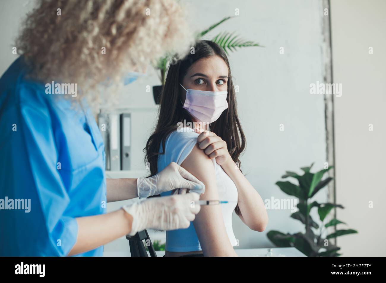 Doctor using a cotton swab with alcohol to clean woman's arm before ...