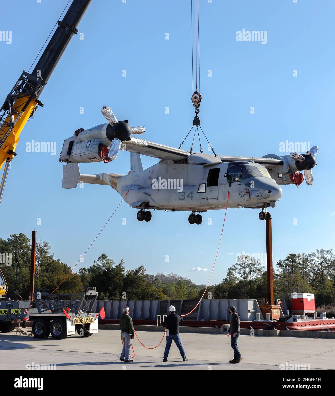 A stricken MV-22 Osprey is lifted off a barge after being delivered to ...