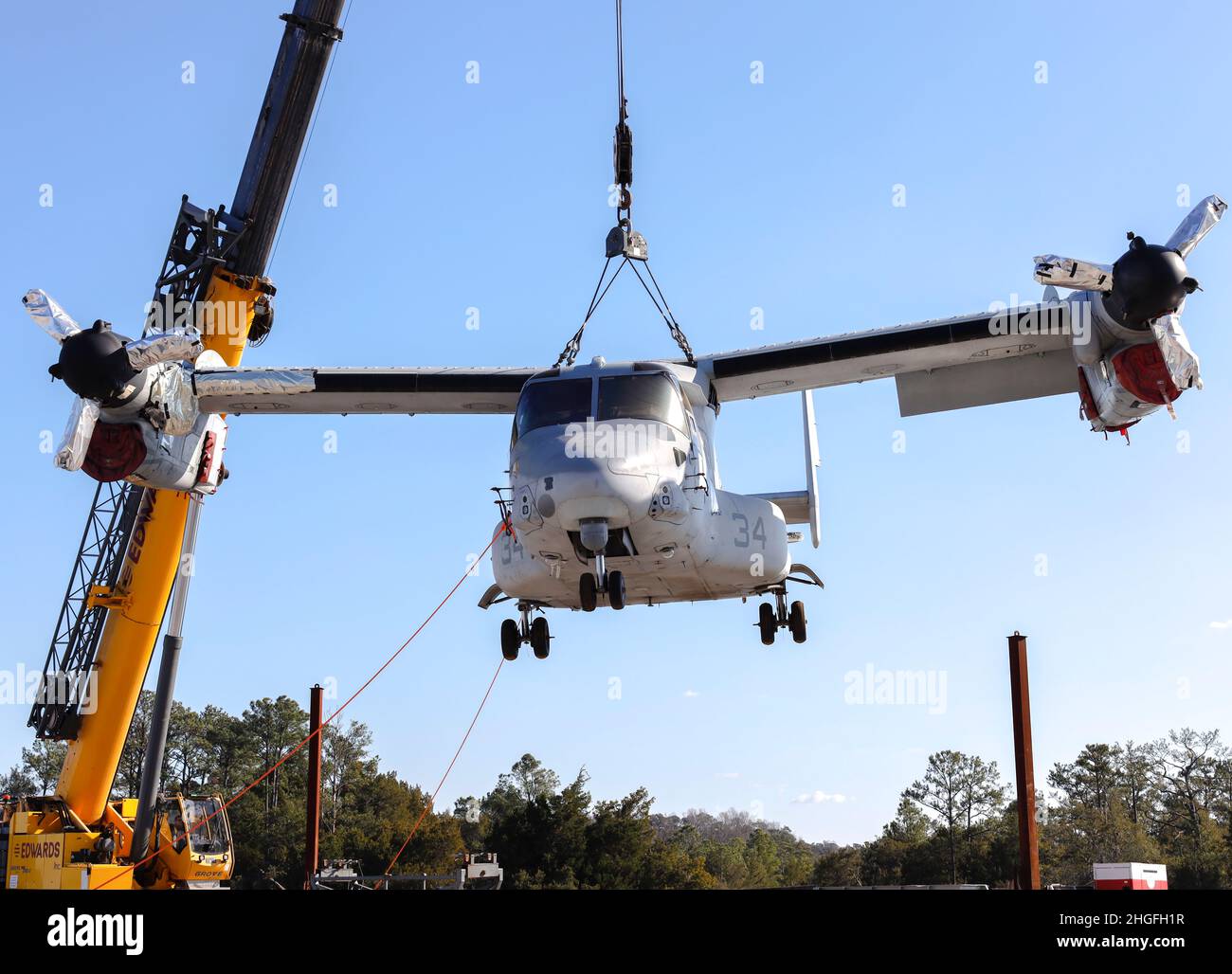A stricken MV-22 Osprey is lifted off a barge after being delivered to ...