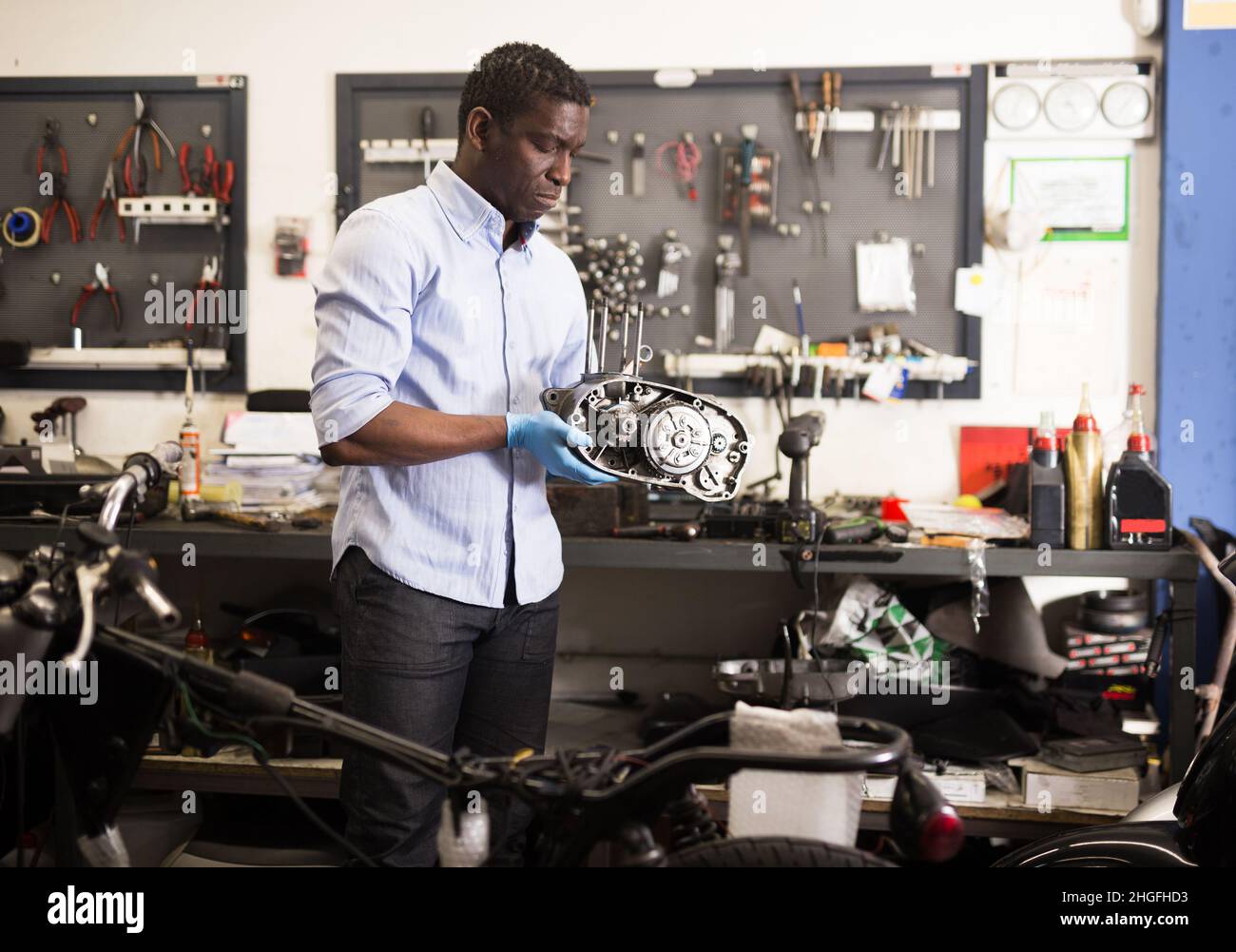 Mechanic installs a repaired engine on a motorcycle Stock Photo - Alamy
