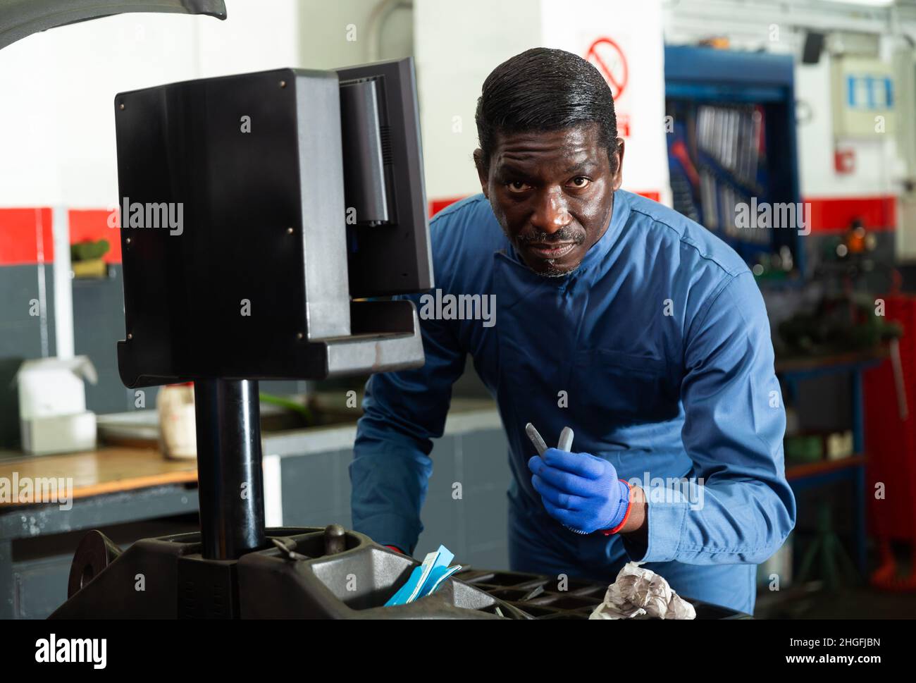 Mechanic balancing tire in auto repair shop using computer Stock Photo ...