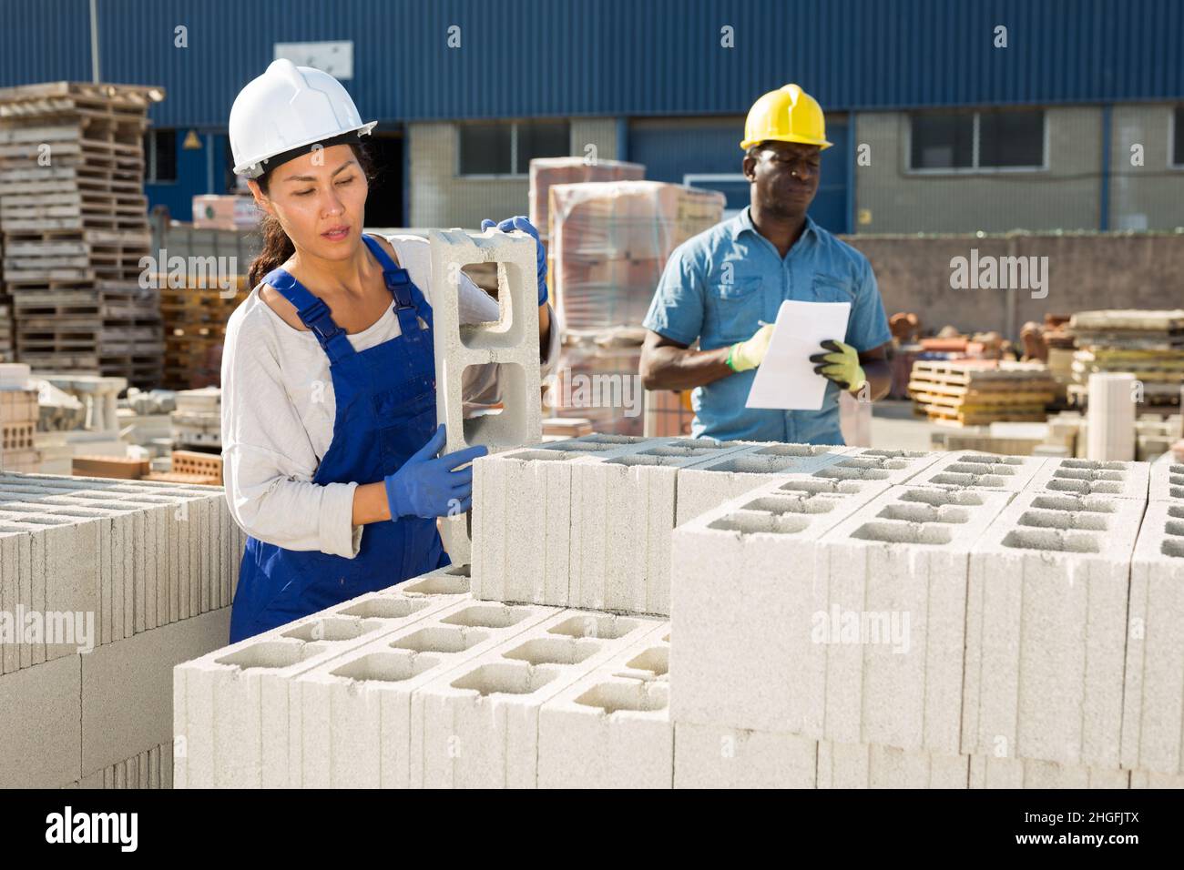 Two builders in construction material storage Stock Photo - Alamy
