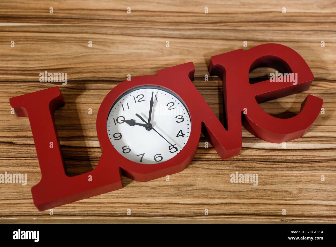 love wooden letters on clock in red color Stock Photo - Alamy