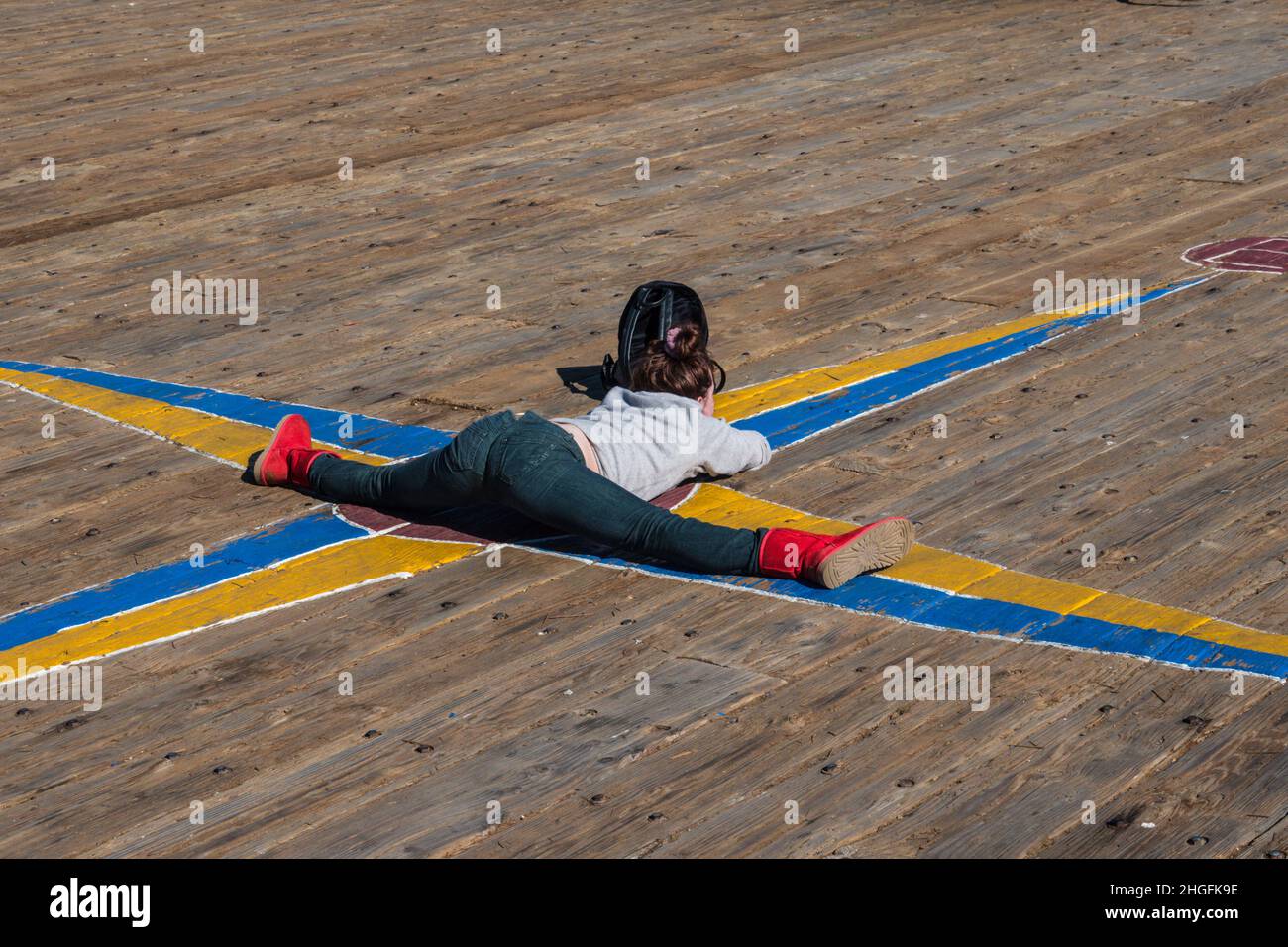 A young woman doing splits on a Stearns Wharf in Santa Barbara ...