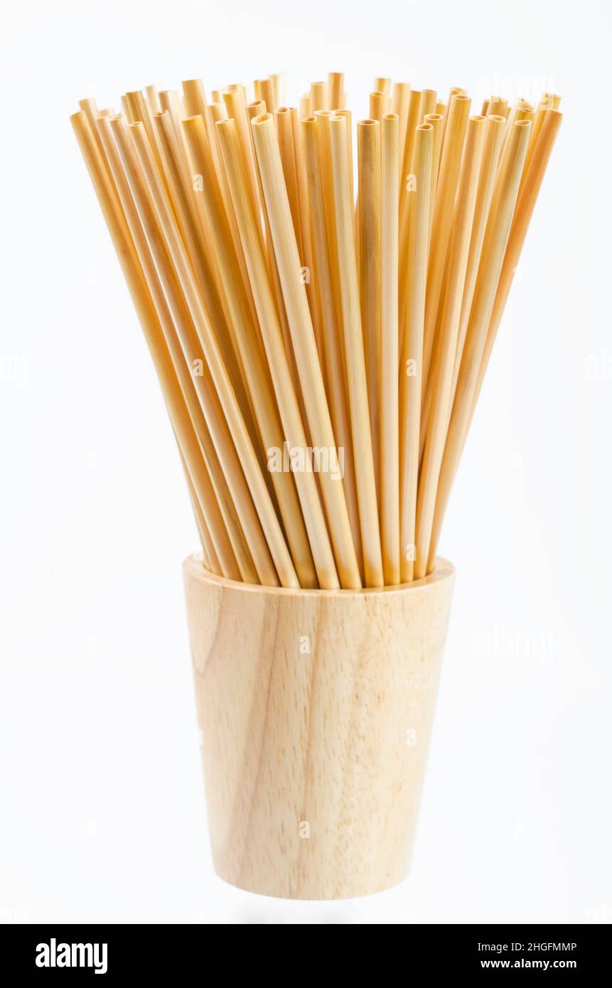 Wheat straw for drinking water in wooden glass on white background ...